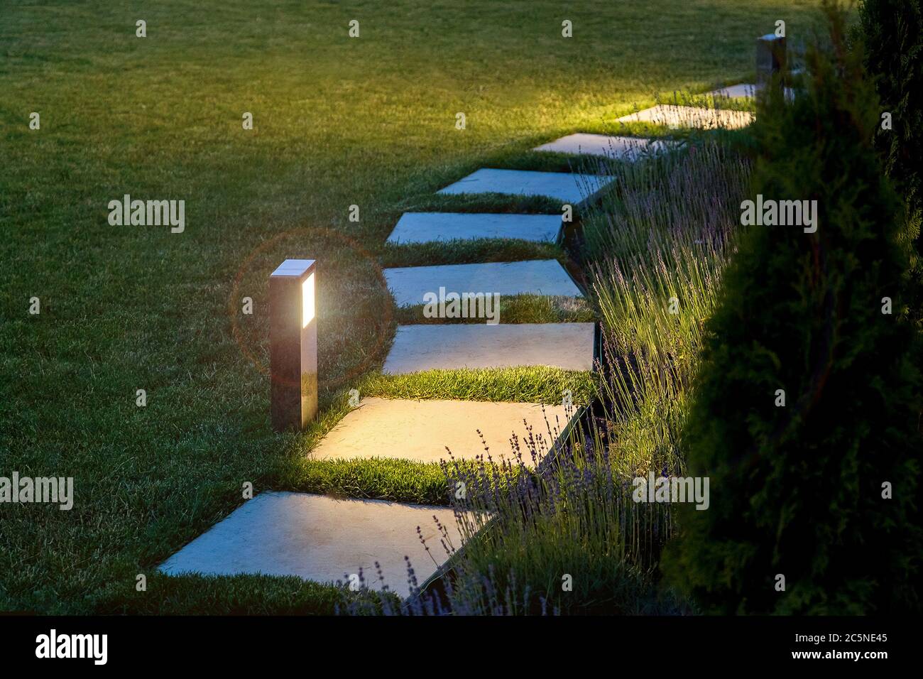 marble path of square tiles illuminated by a lamp glowing with a warm ...