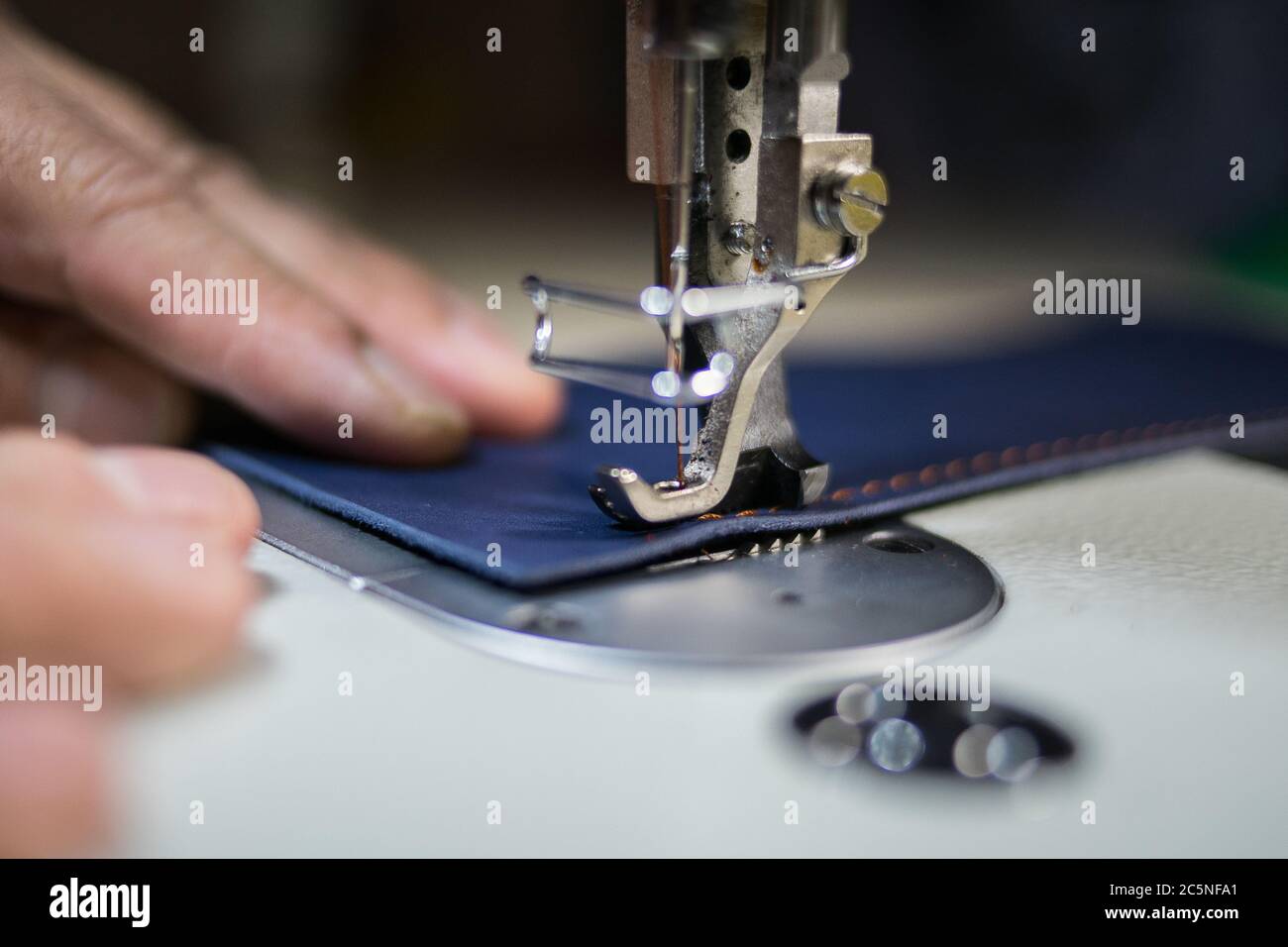 A man sews from leather on a sewing machine. Hands and sewing Stock ...