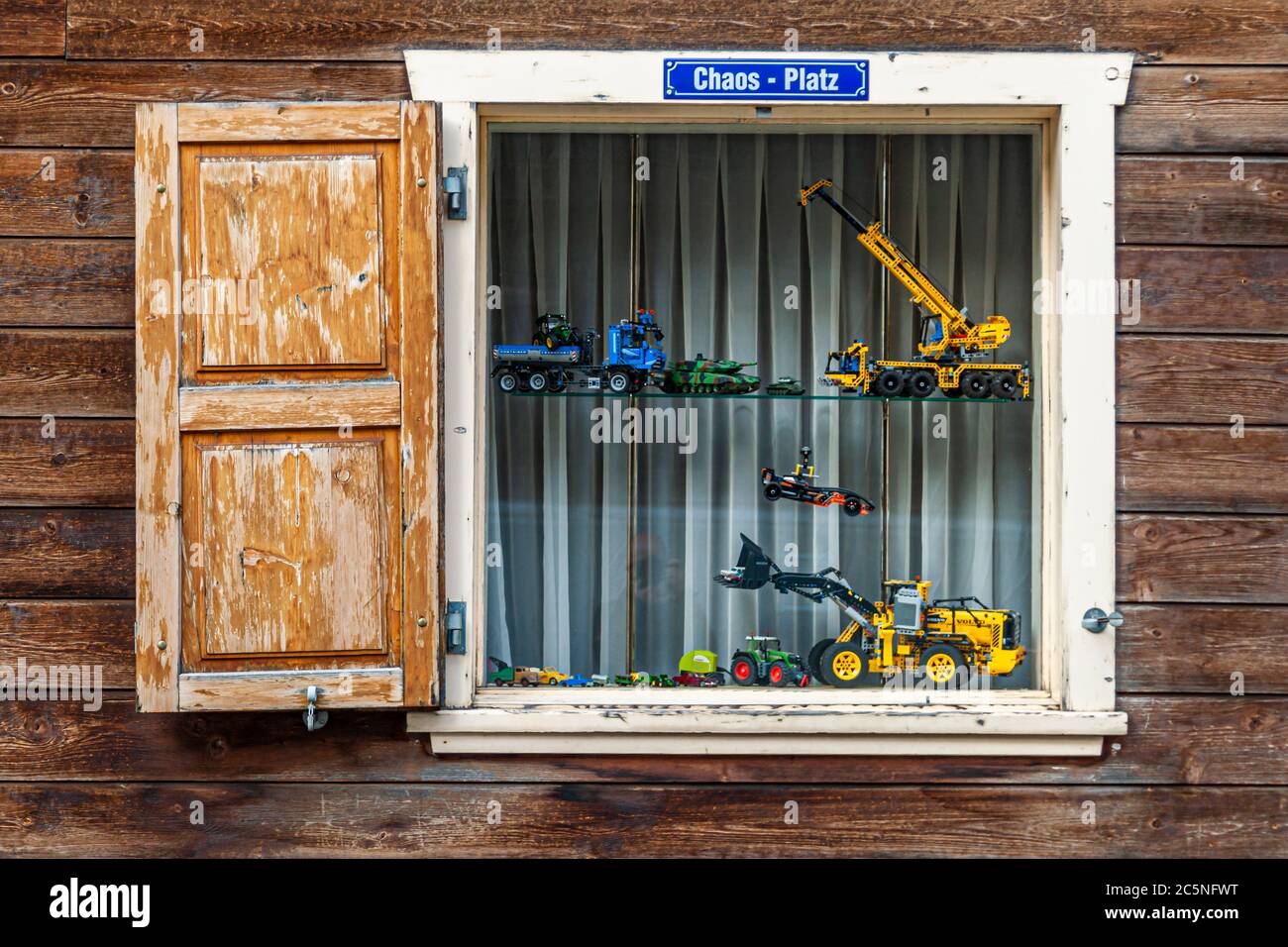 Window decorated with toy cars under the title: Chaos Square in ...