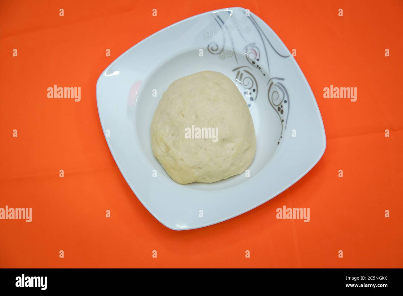 Raw dough lying on the plate on a white background. A piece of dough ...