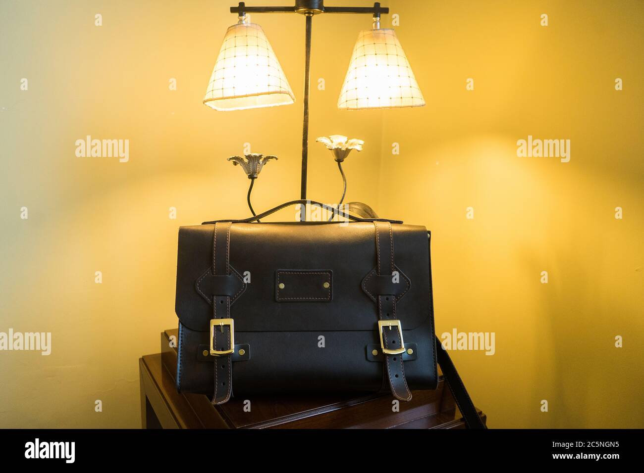 Handmade black leather bag on the background of an expensive lamp Stock ...