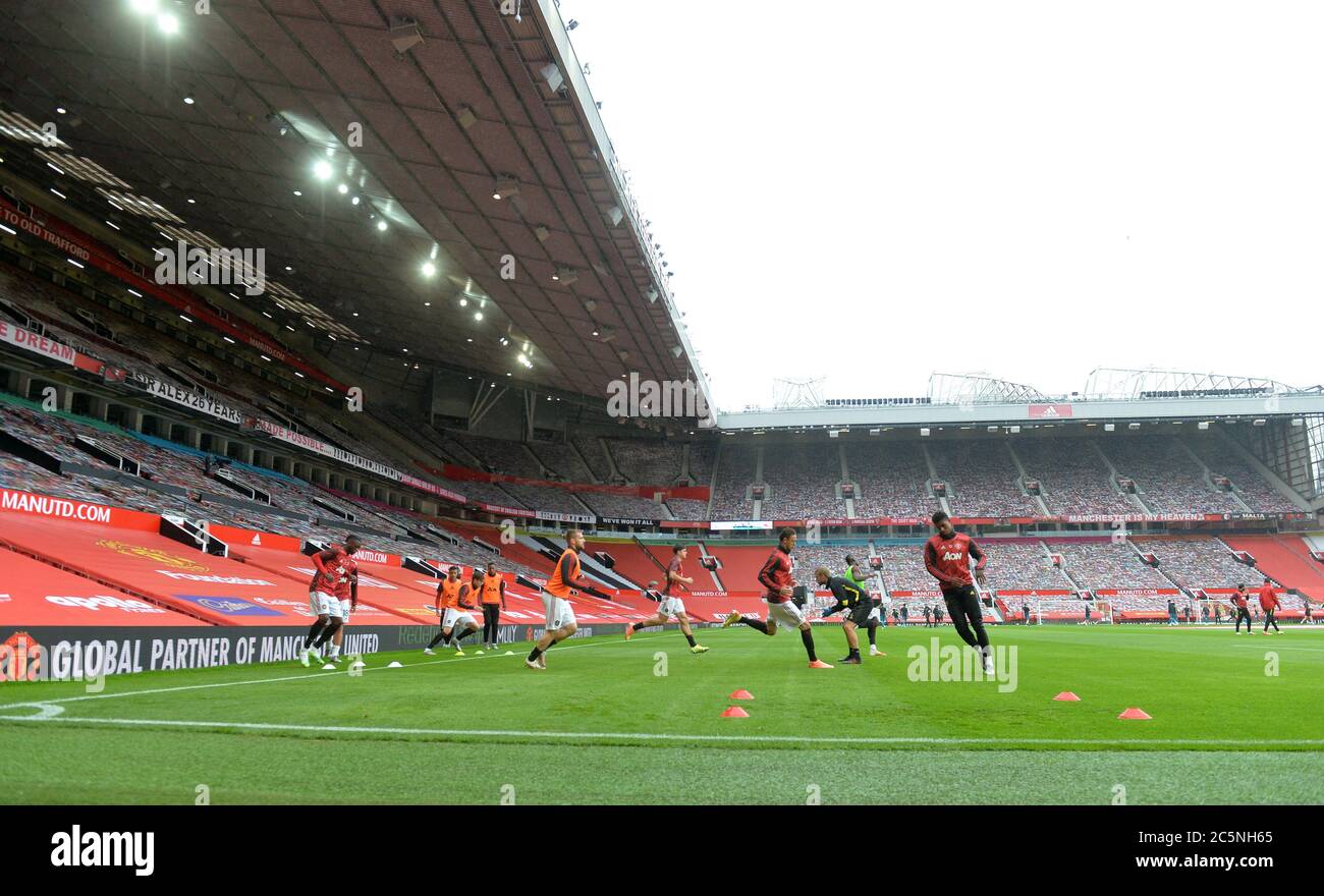 Manchester United players warm up in front of the empty stadium before ...