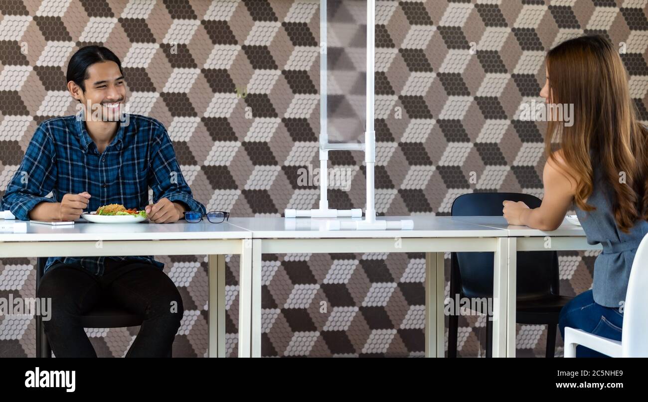 Asian young couple eating out together at new normal social distance ...