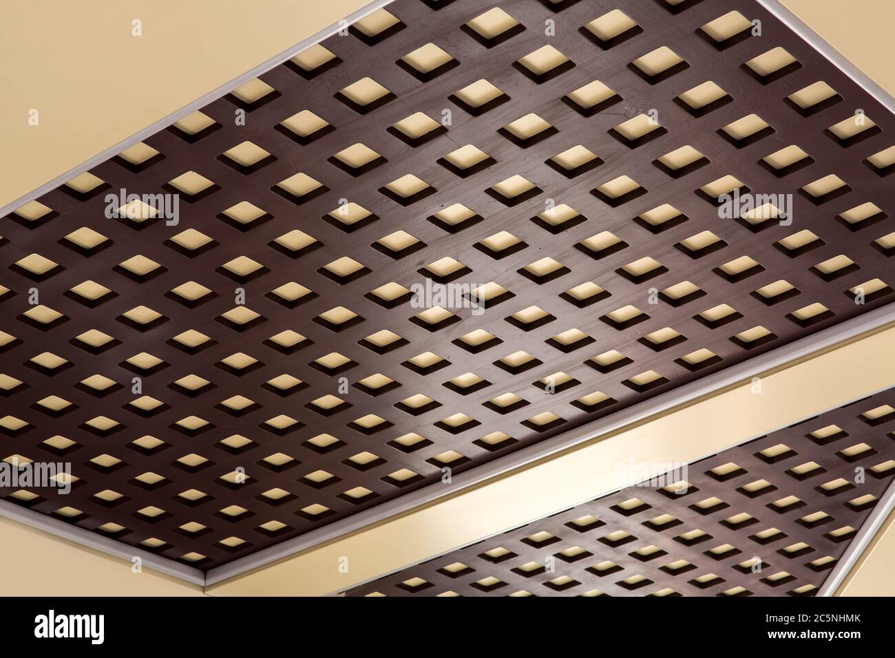 pergola wooden ceiling with square brown cells on a beige surface ...
