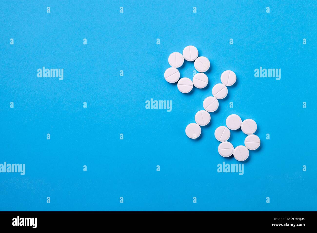 A percent sign of pills on a blue background top view with copy space ...