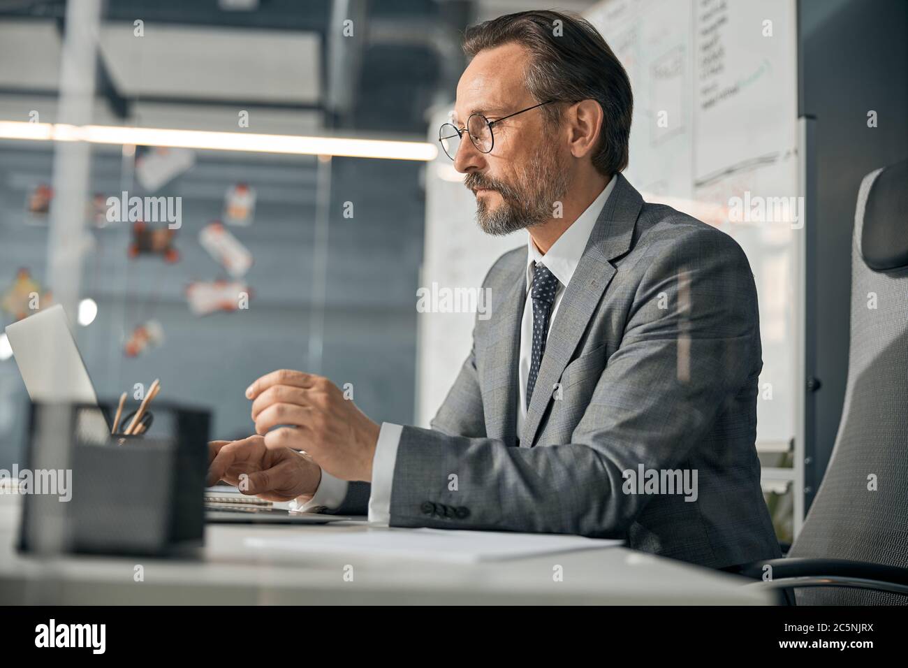 Employee looking at computer monitor during working day in office Stock ...