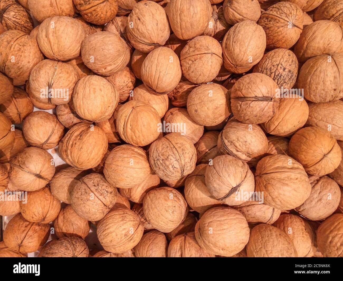 Pile of walnuts in their shells background Stock Photo - Alamy
