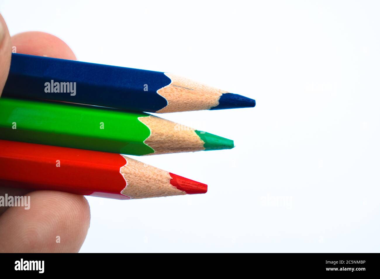 One person holding three different colored wood pencil crayon in his ...