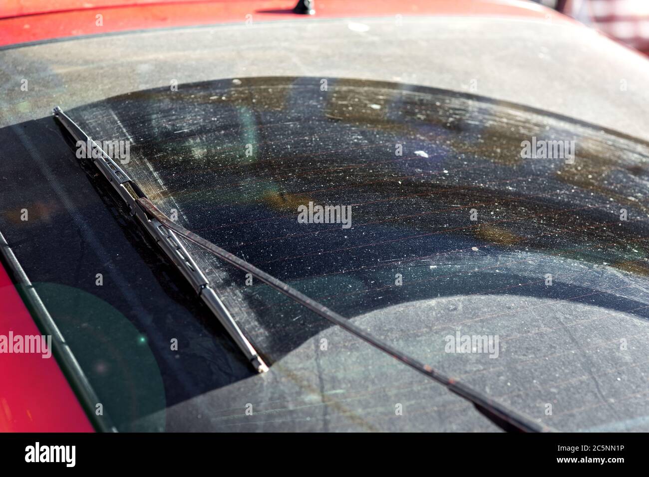 Dirty car glass rear view of a red car in the back of a hatchback with ...