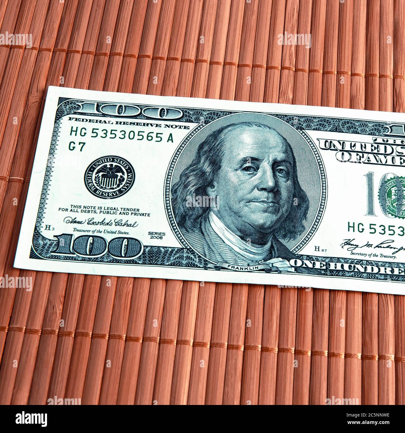 A hundred American dollars bill in close-up on a bambuk mat made of ...
