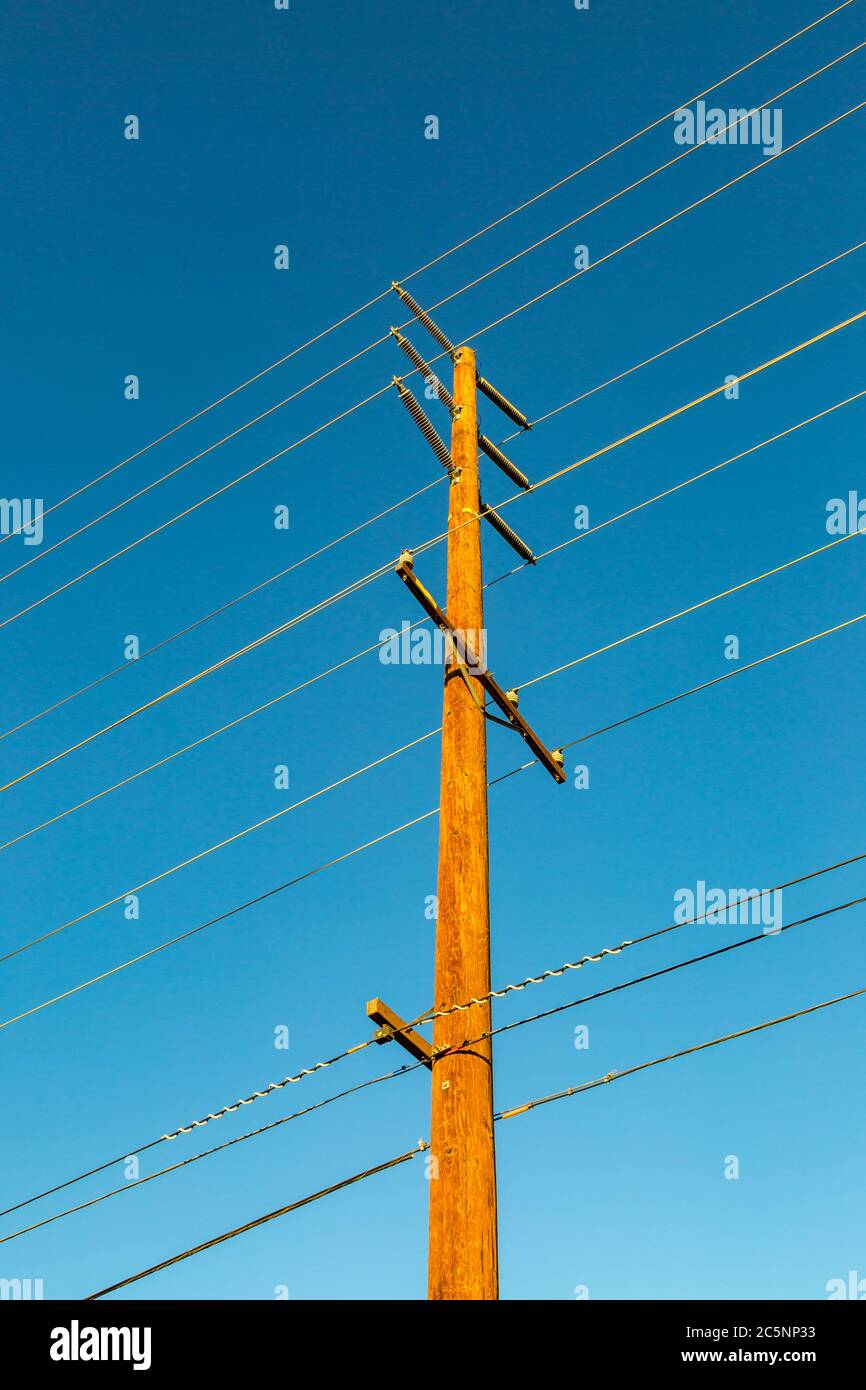 Wires and a wooden pylon against a clear blue sky Stock Photo - Alamy