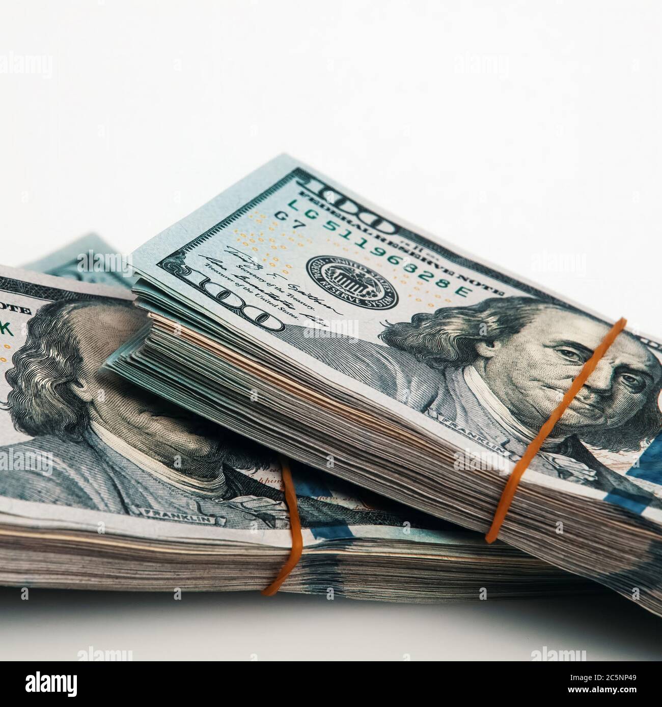 Isolated bundle of dollars. A large stack of hundred-dollar bills lies ...