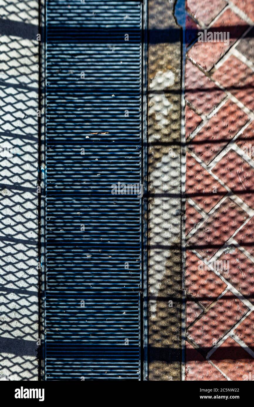 Shadows falling from a fence onto bricks and concrete Stock Photo - Alamy