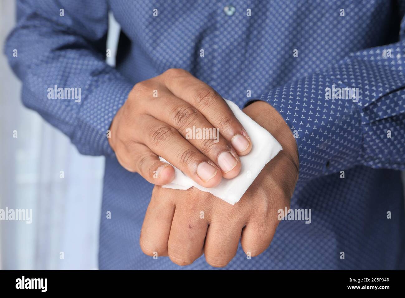 man disinfecting his hands with a wet wipe Stock Photo - Alamy