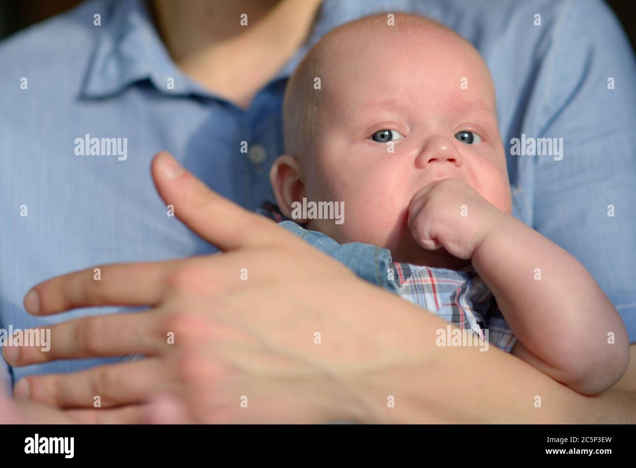 A father holds his little son, protecting him with hand. Small depth of ...