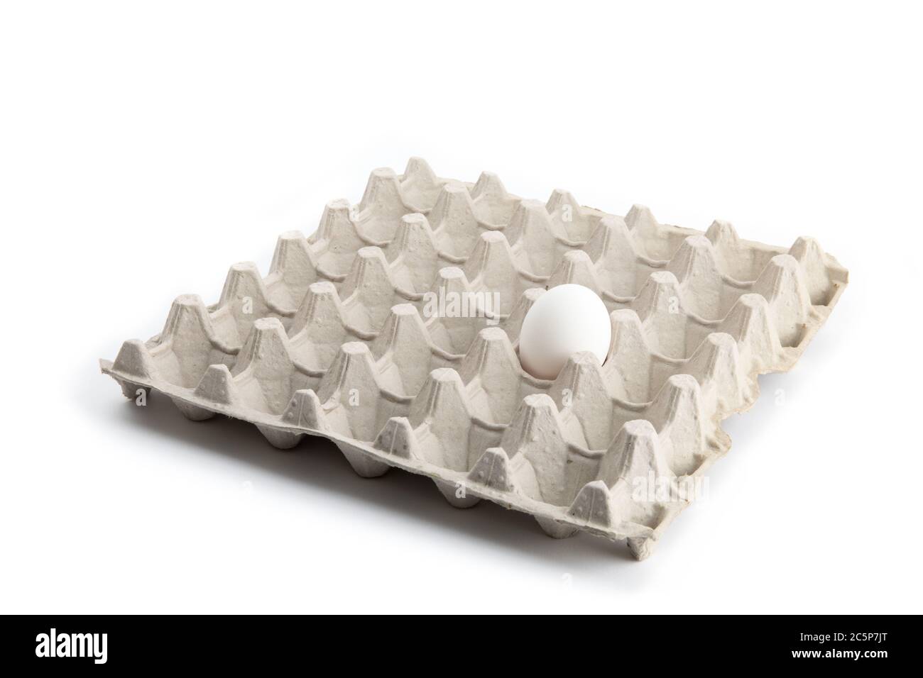 a flat of 30 eggs with one white egg left isolated on white Stock Photo ...