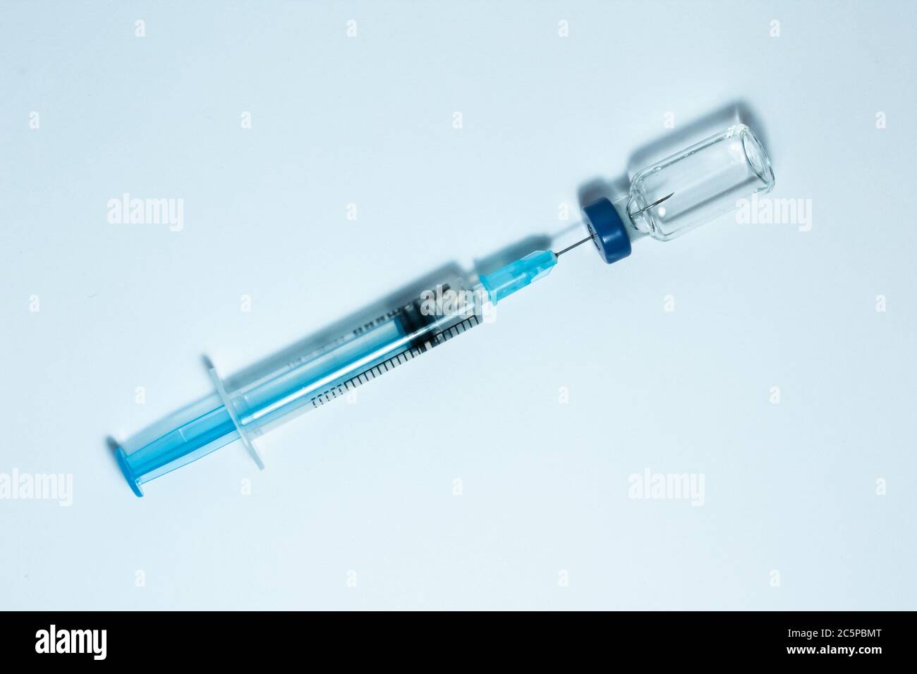 Glass medicine bottle with injection fluid with blue aluminium cap and ...