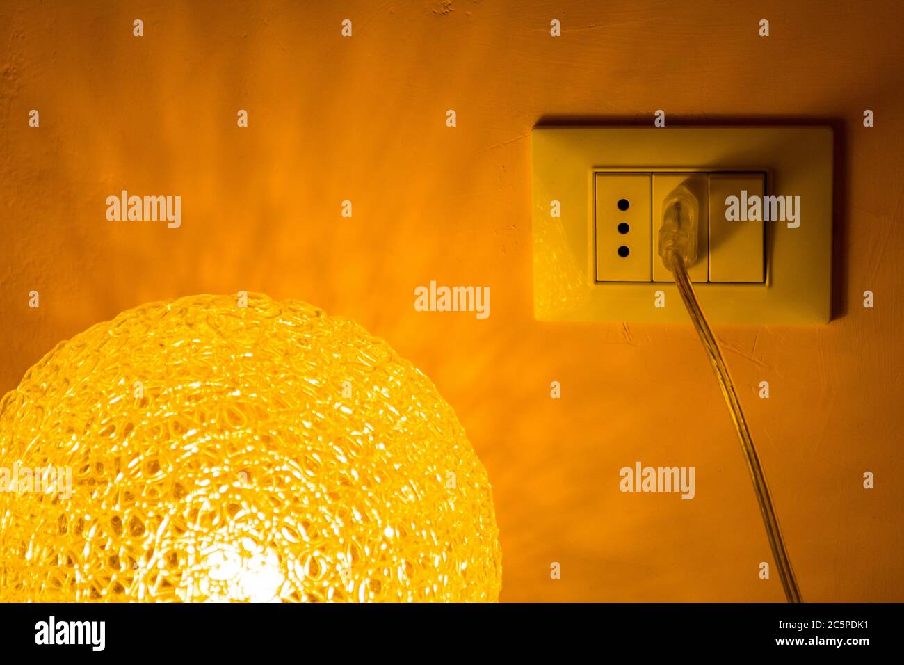 Power plug by a lighted table lamp Stock Photo - Alamy