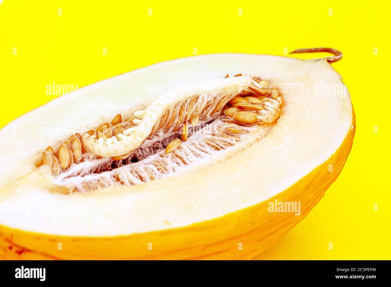 Yellow melon cut in half on yellow background. Summer fuit and healthy ...