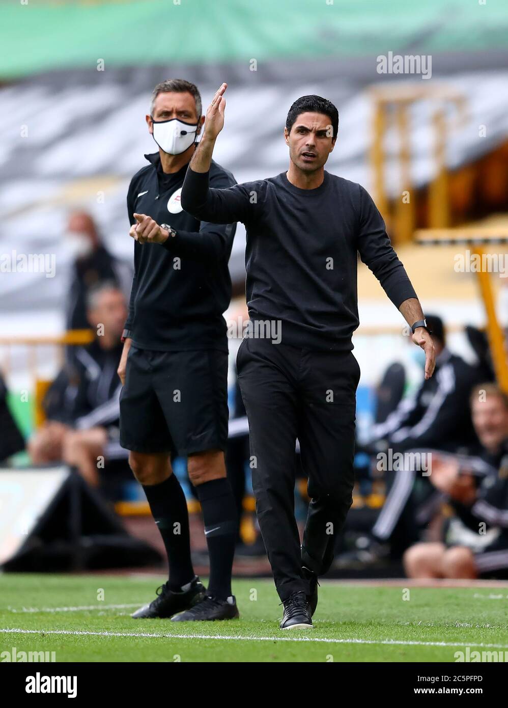 Arsenal manager Mikel Arteta (right) gestures on the touchline in front ...