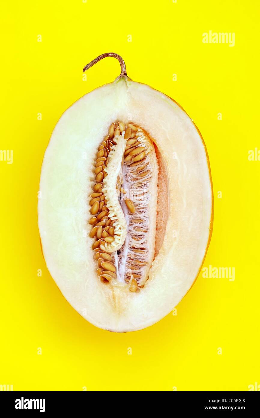 Yellow melon cut in half on yellow background. Summer fuit, minimalism ...