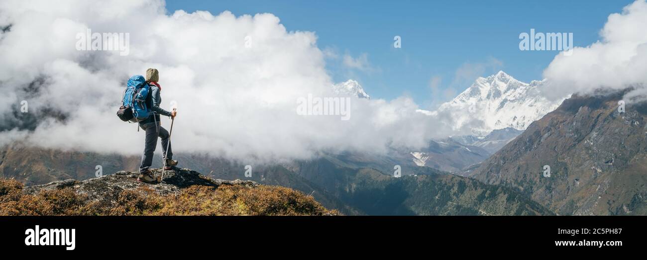 Young hiker backpacker woman using trekking poles enjoying the Nuptse ...