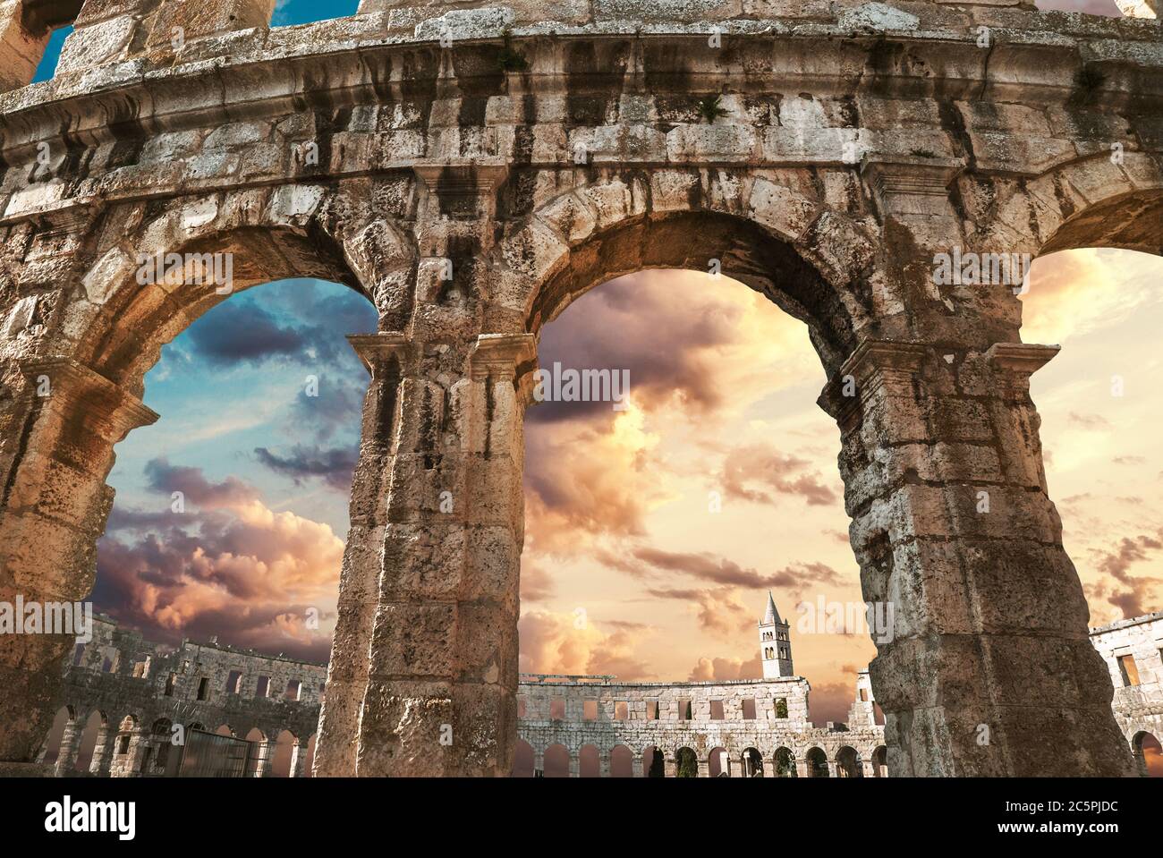 View on church bell tower through amphitheater arches Stock Photo - Alamy