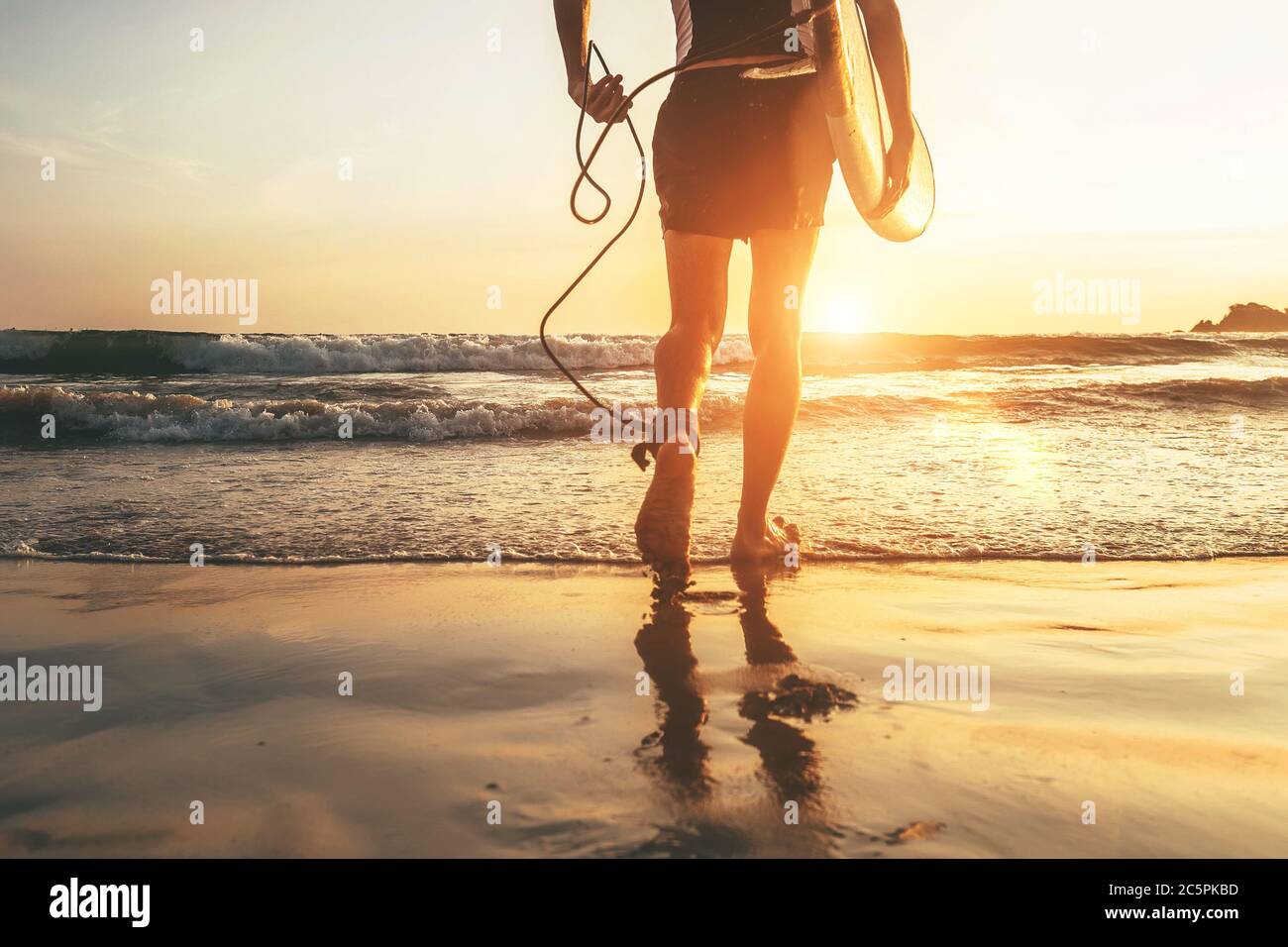 Man surfer runing in ocean with surfboard. Close up legs image at ...