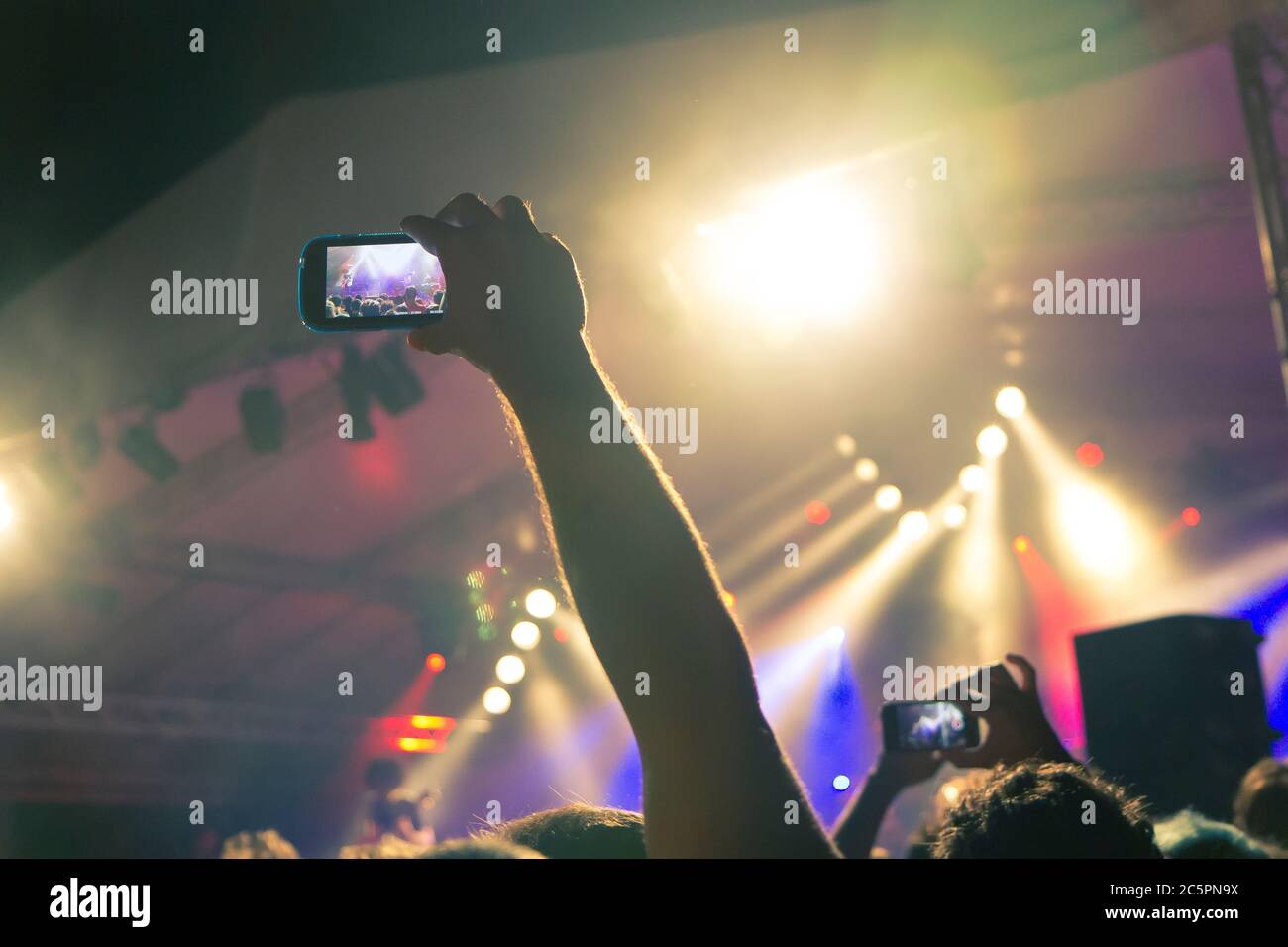 Concert crowd point of view in front of a lit stage for a night ...