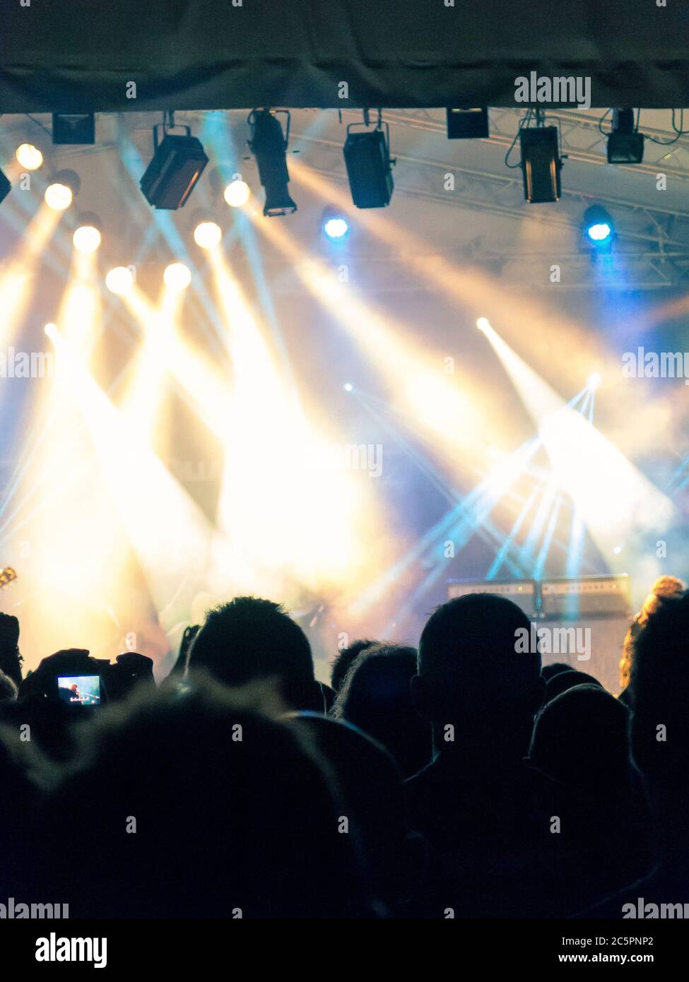 Concert crowd point of view in front of a lit stage for a night ...