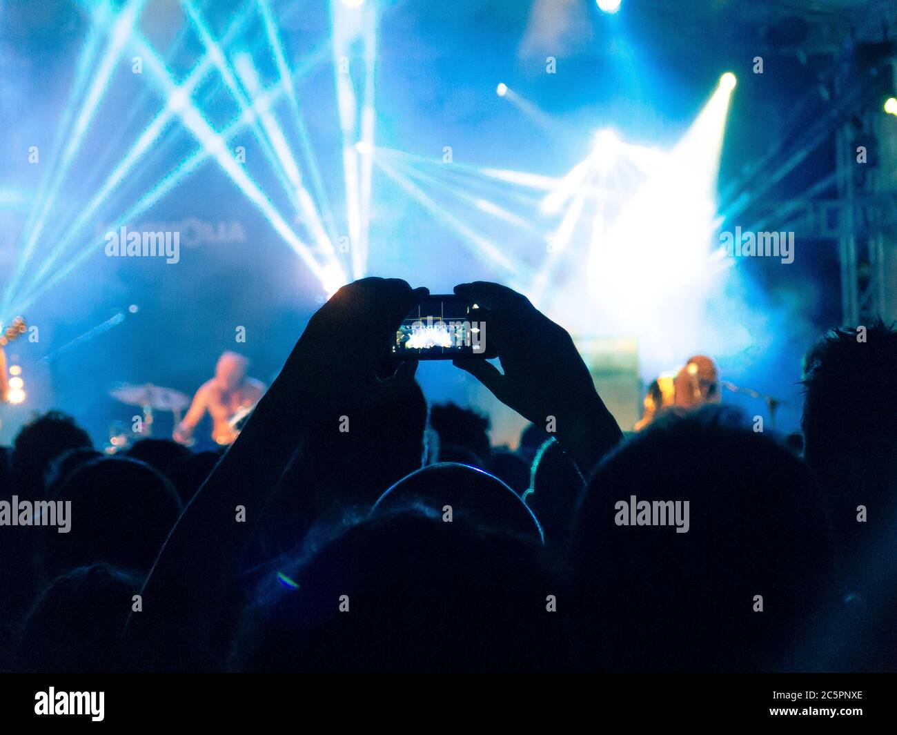 Concert crowd point of view in front of a lit stage for a night ...