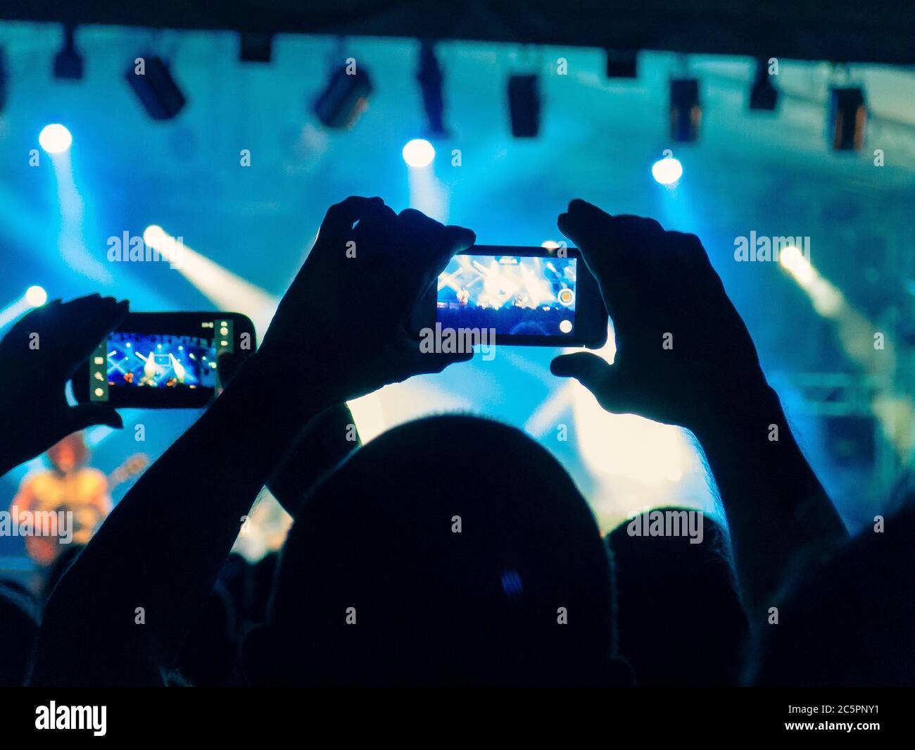 Concert crowd point of view in front of a lit stage for a night ...