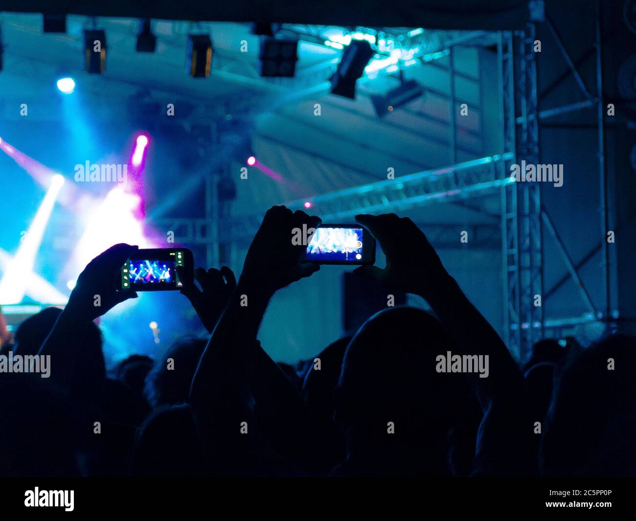 Concert crowd point of view in front of a lit stage for a night ...