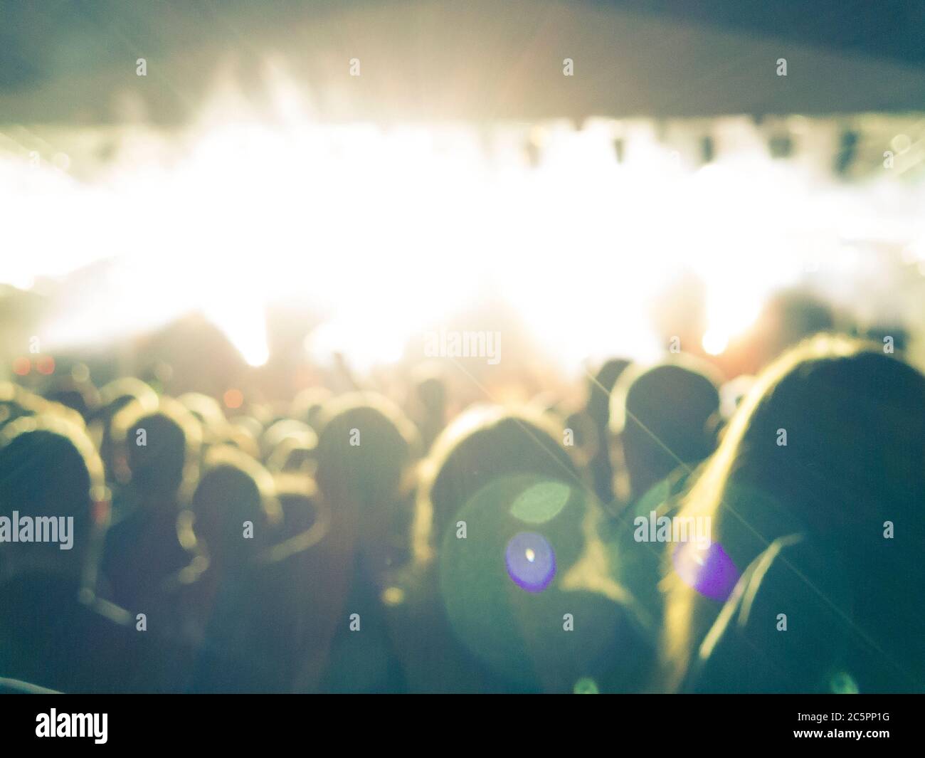 Concert crowd point of view in front of a lit stage for a night ...