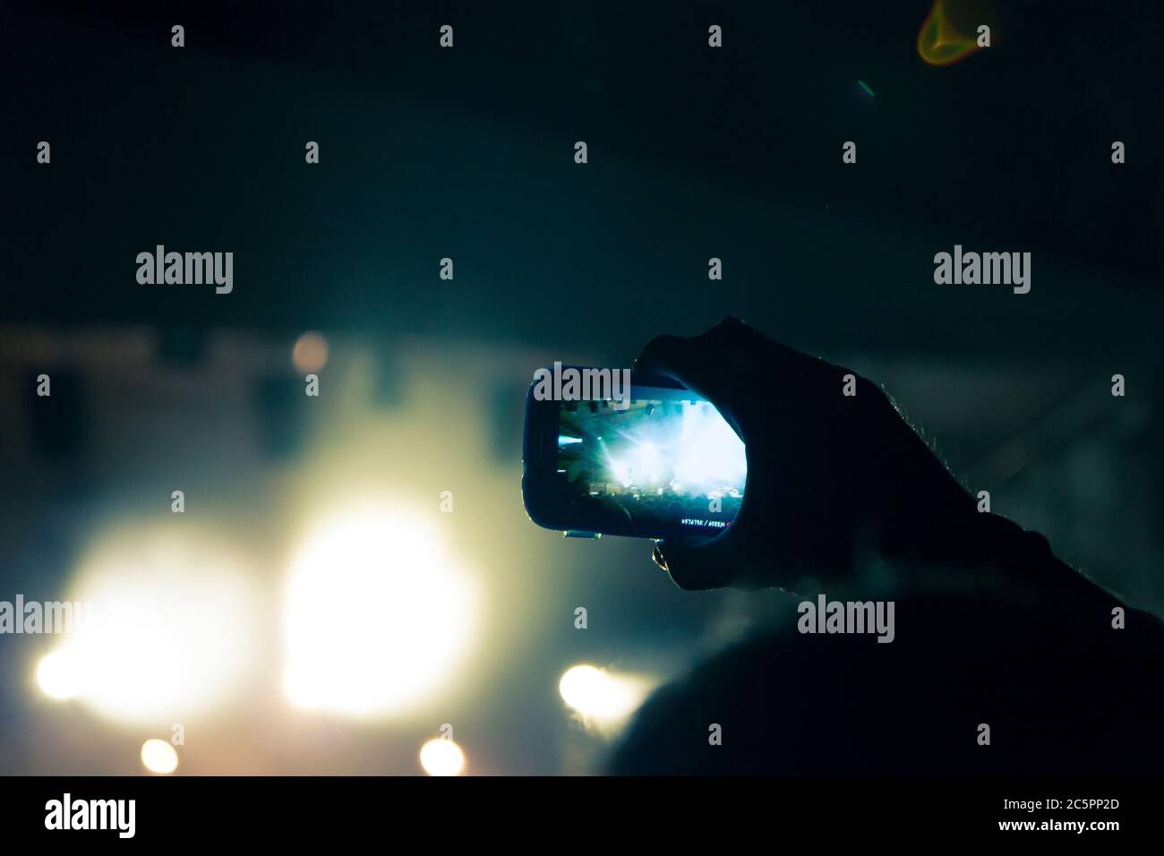 Concert crowd point of view in front of a lit stage for a night ...