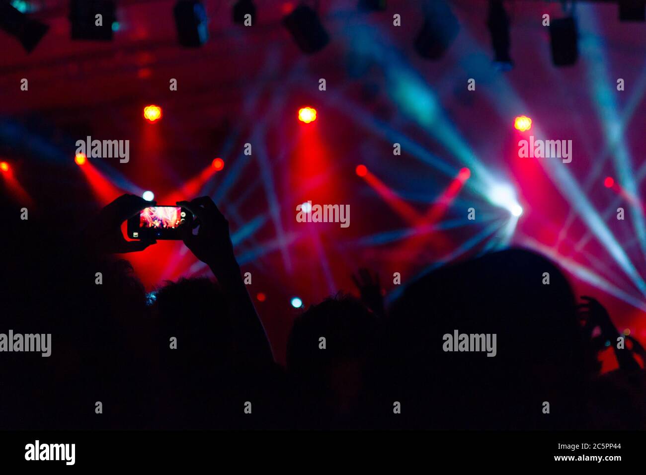 Concert crowd point of view in front of a lit stage for a night ...