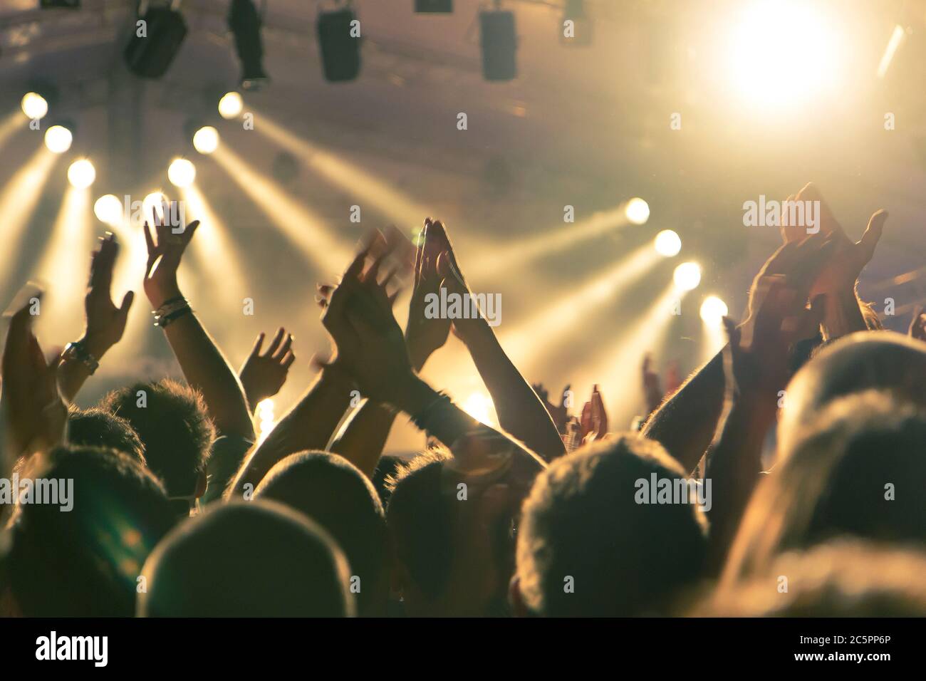 Concert crowd point of view in front of a lit stage for a night ...