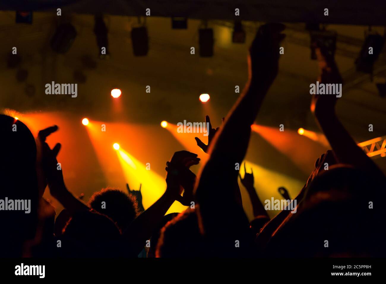 Concert crowd point of view in front of a lit stage for a night ...