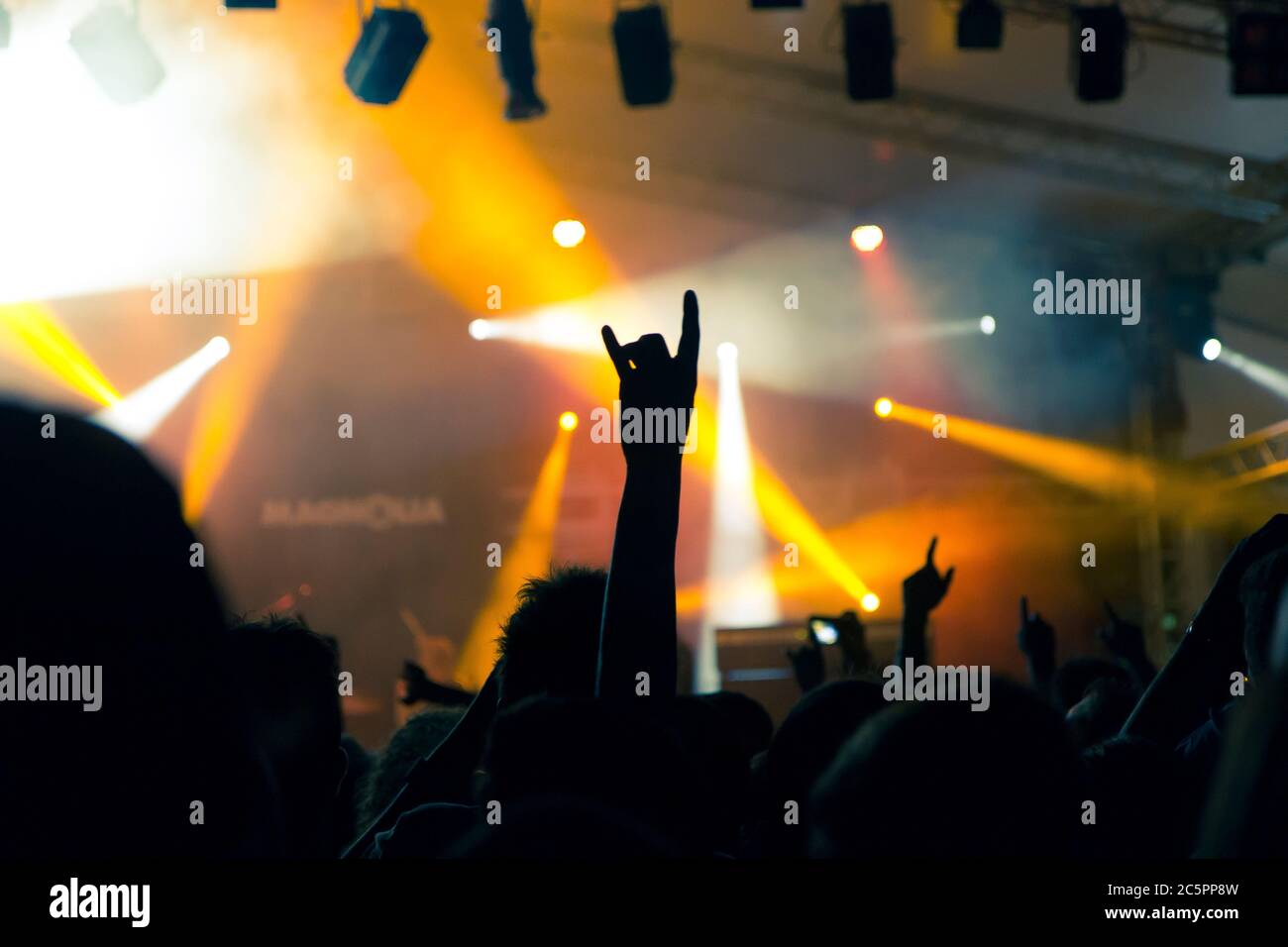 Concert crowd point of view in front of a lit stage for a night ...