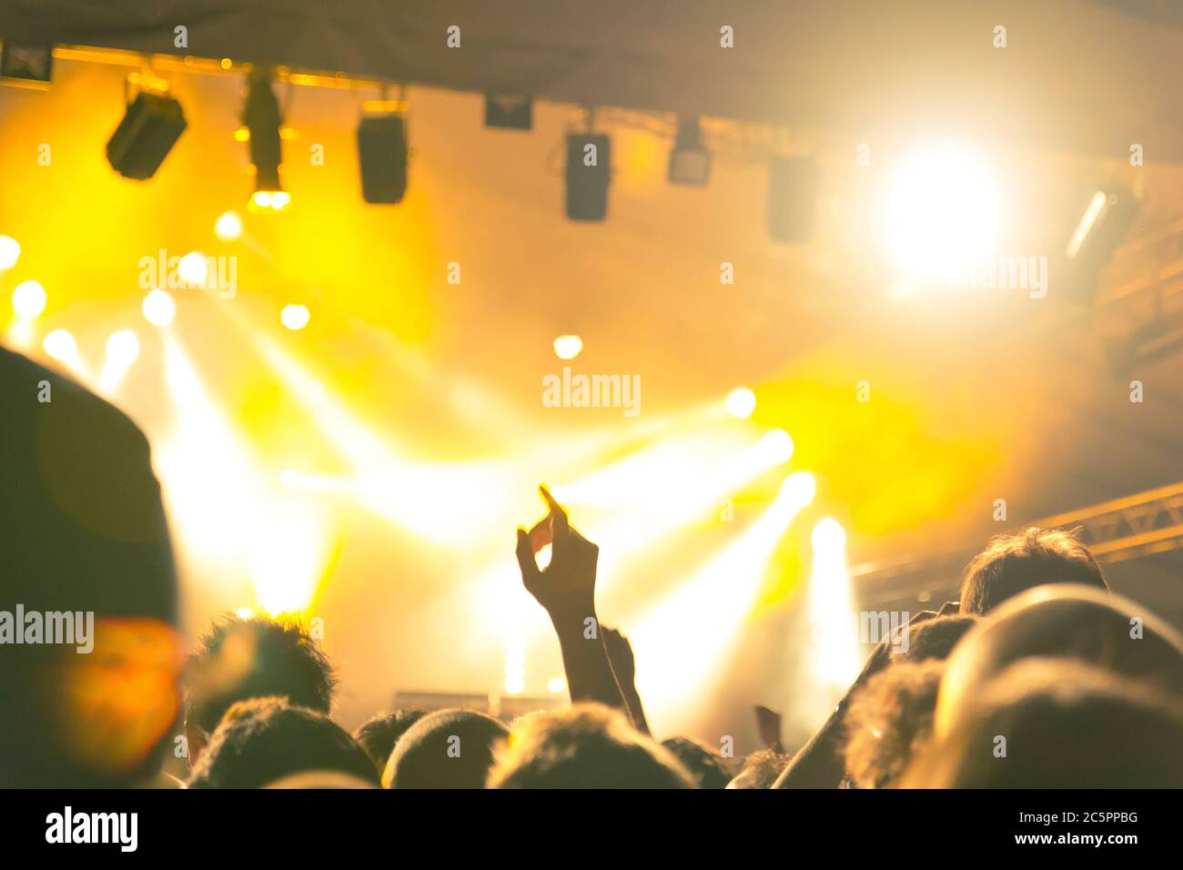 Concert crowd point of view in front of a lit stage for a night ...