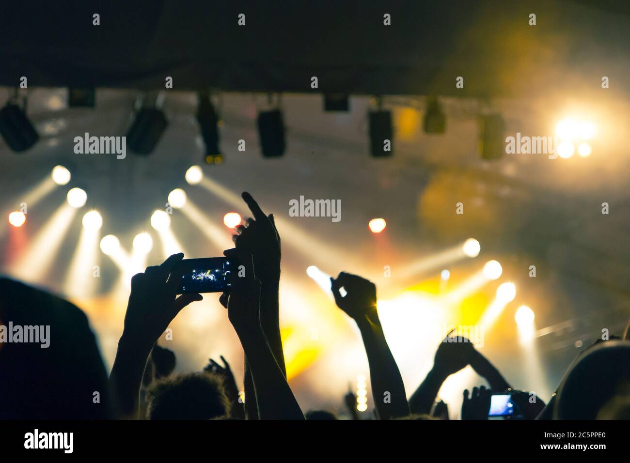 Concert crowd point of view in front of a lit stage for a night ...
