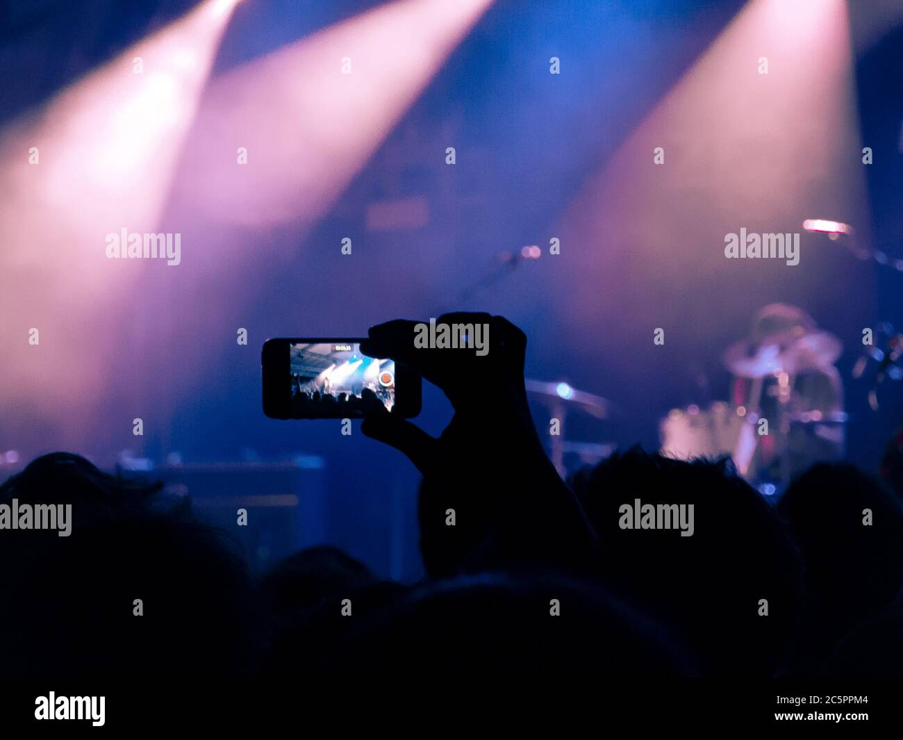 Concert crowd point of view in front of a lit stage for a night ...