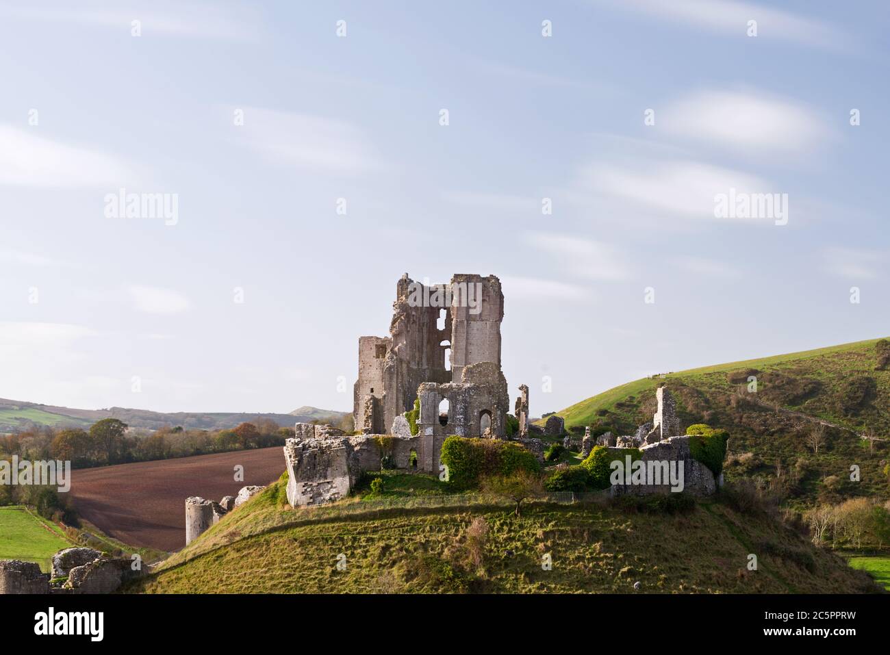 A sunny autumnal view of the medieval Corfe Castle in Dorset. A ...