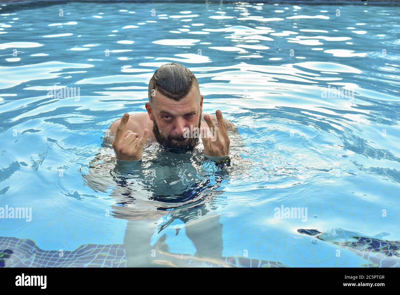 Bearded man swimming in a pool. Man with a beard in the pool. Brunette ...