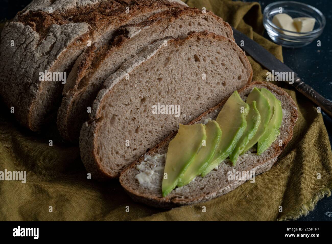 freshly baked country bread sliced with butter and avocado Stock Photo ...