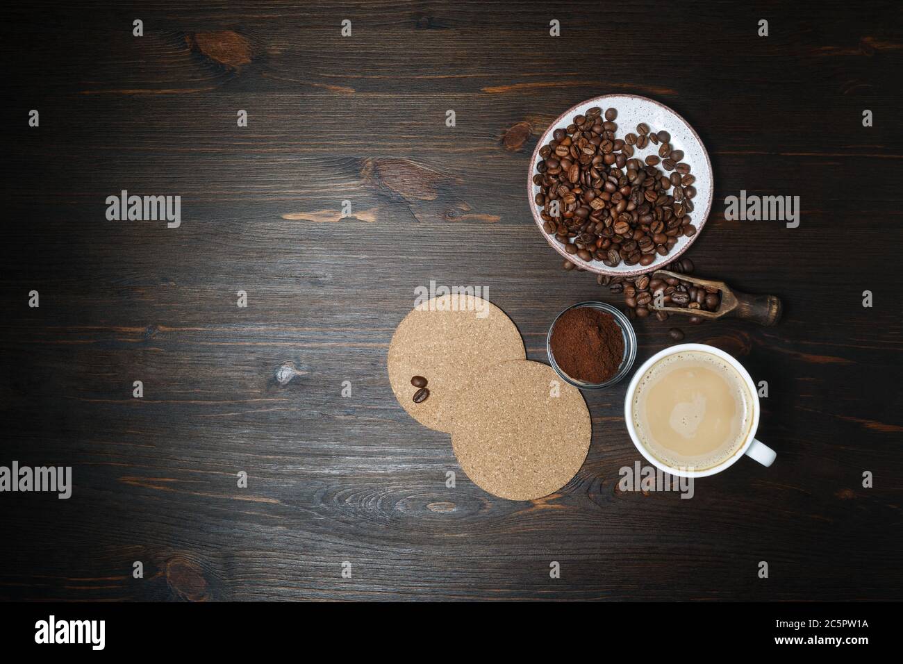 Still life with hot coffee cup, coffee beans, beer coasters and ground ...