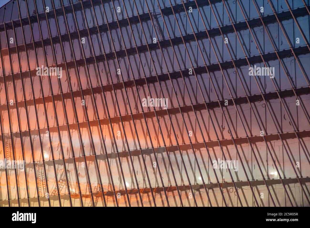 Reflection of the sunset sky in a glass facade of the building ...