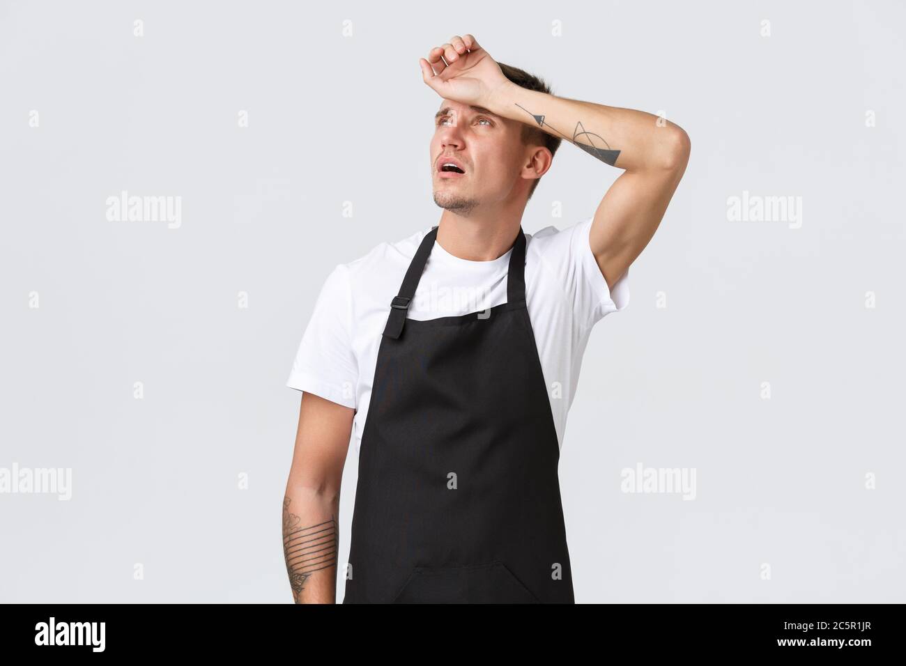 Employees, grocery stores and coffee shop concept. Tired waiter looking ...