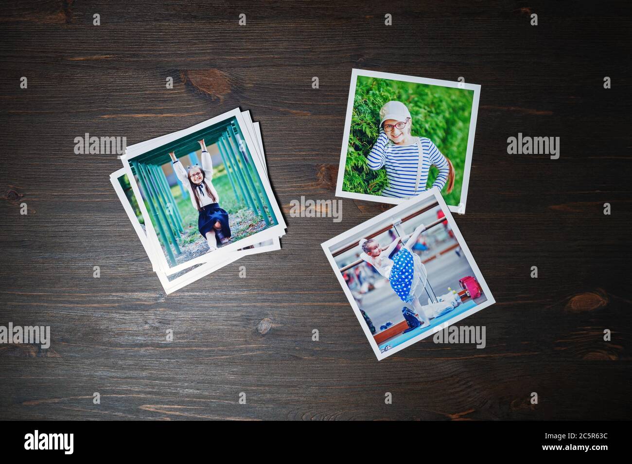 Square photos from a family photo album on wood table background. Flat ...