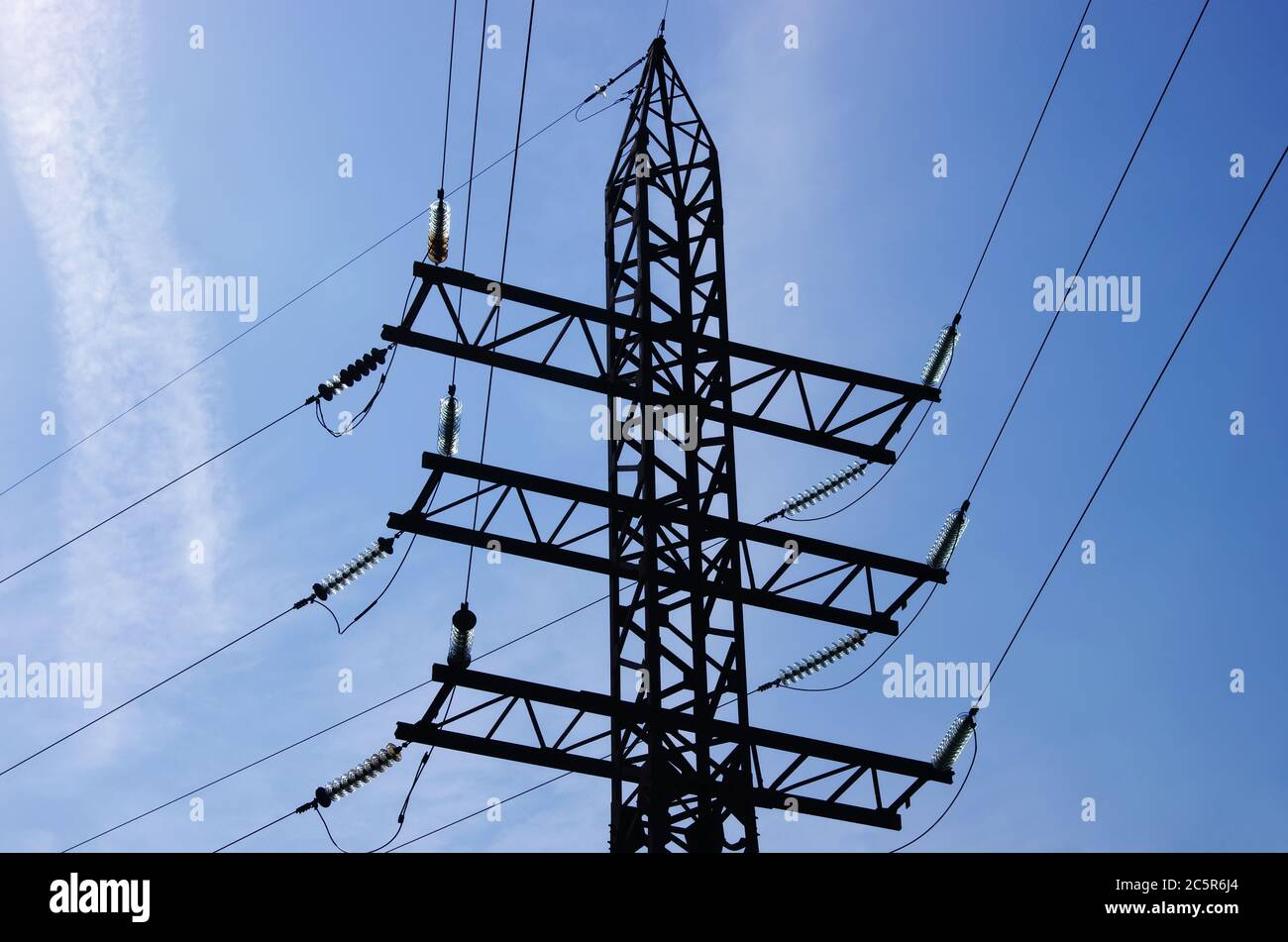Electricity pylon with insulators and power lines. Blue sky background ...